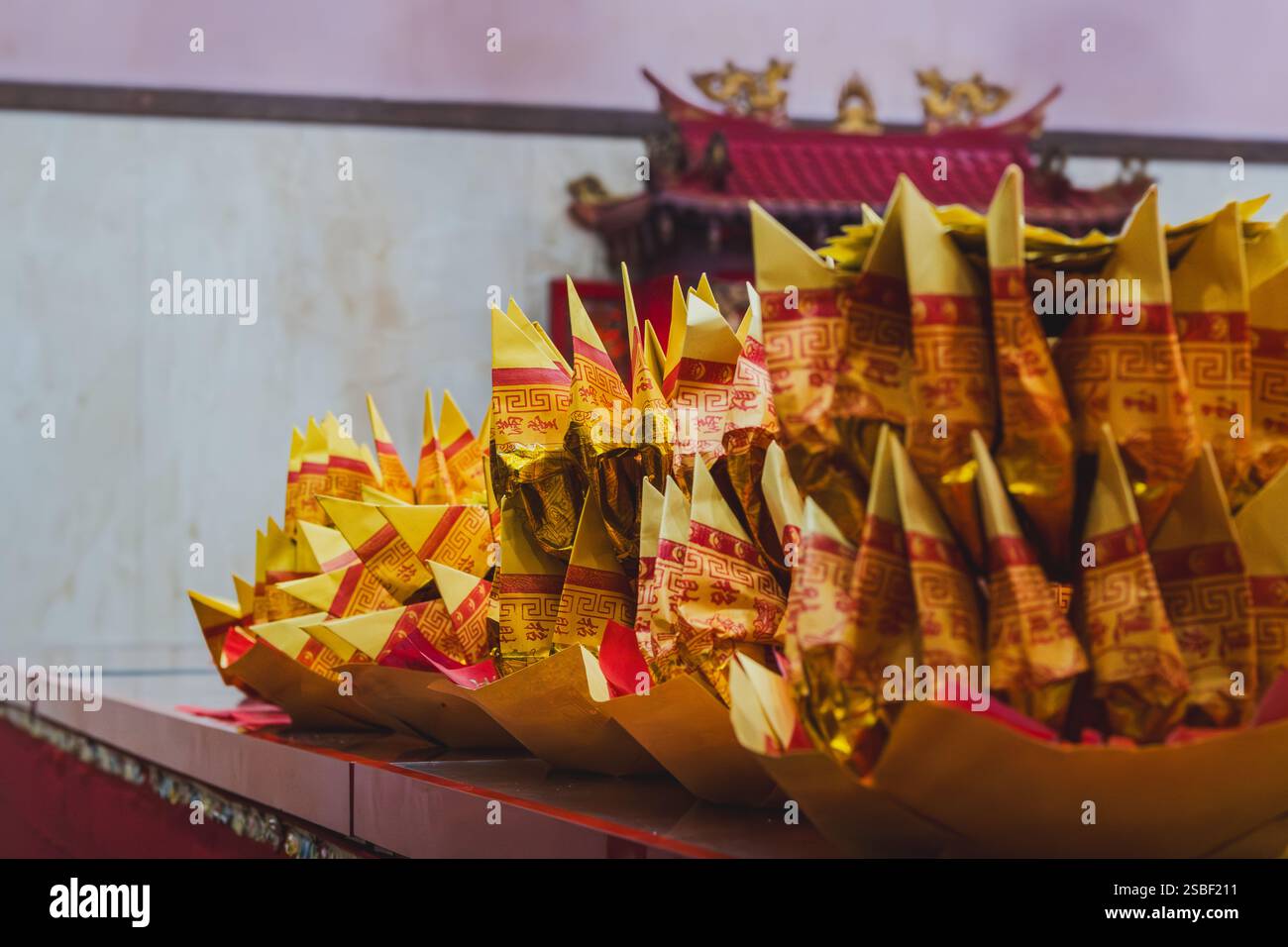 Close-up of folded joss paper money and gold ingots, ready for burning ...