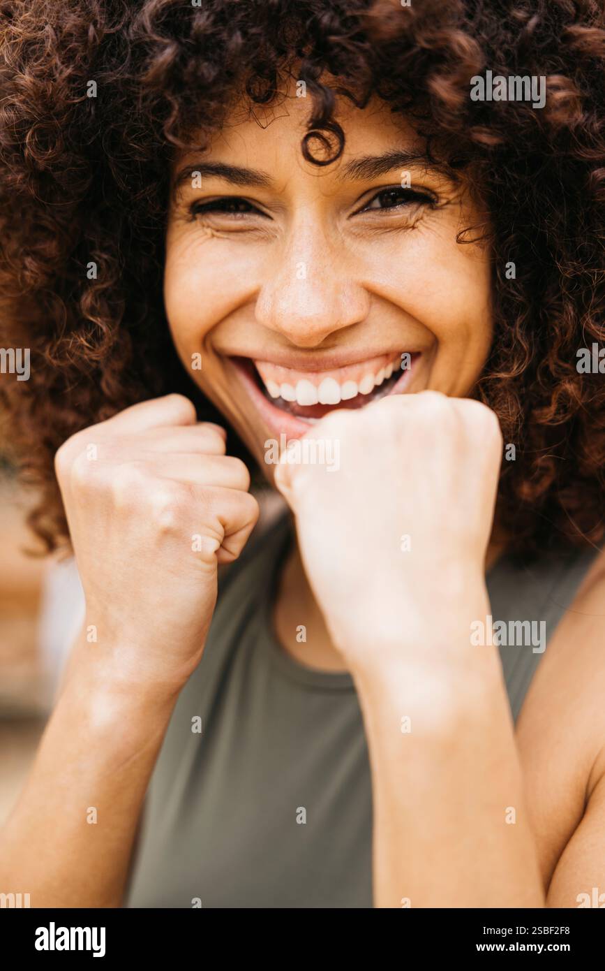 Cheerful young woman smiles cheerfully, posing in a fighting stance ...