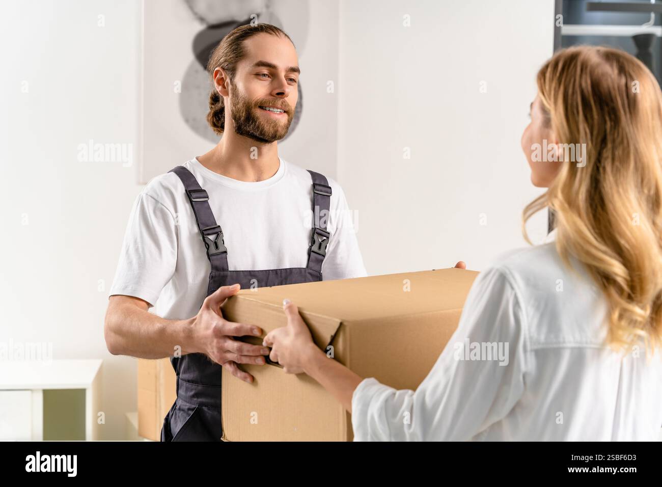 Worker of a delivery services office passing the package to the ...