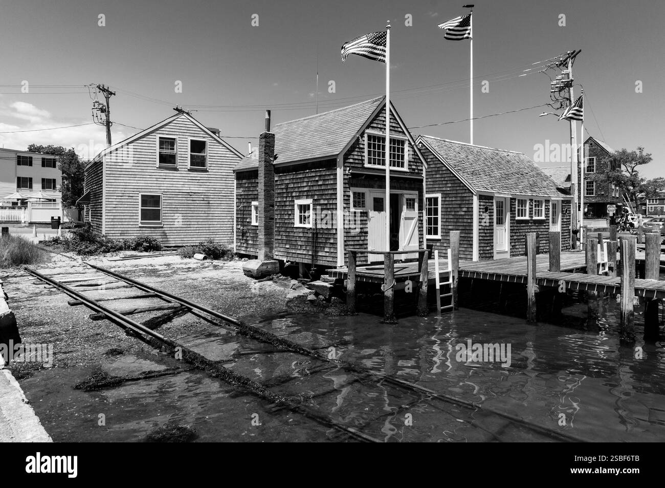Black and white shot of historic harbour buildings and boat ramp on ...