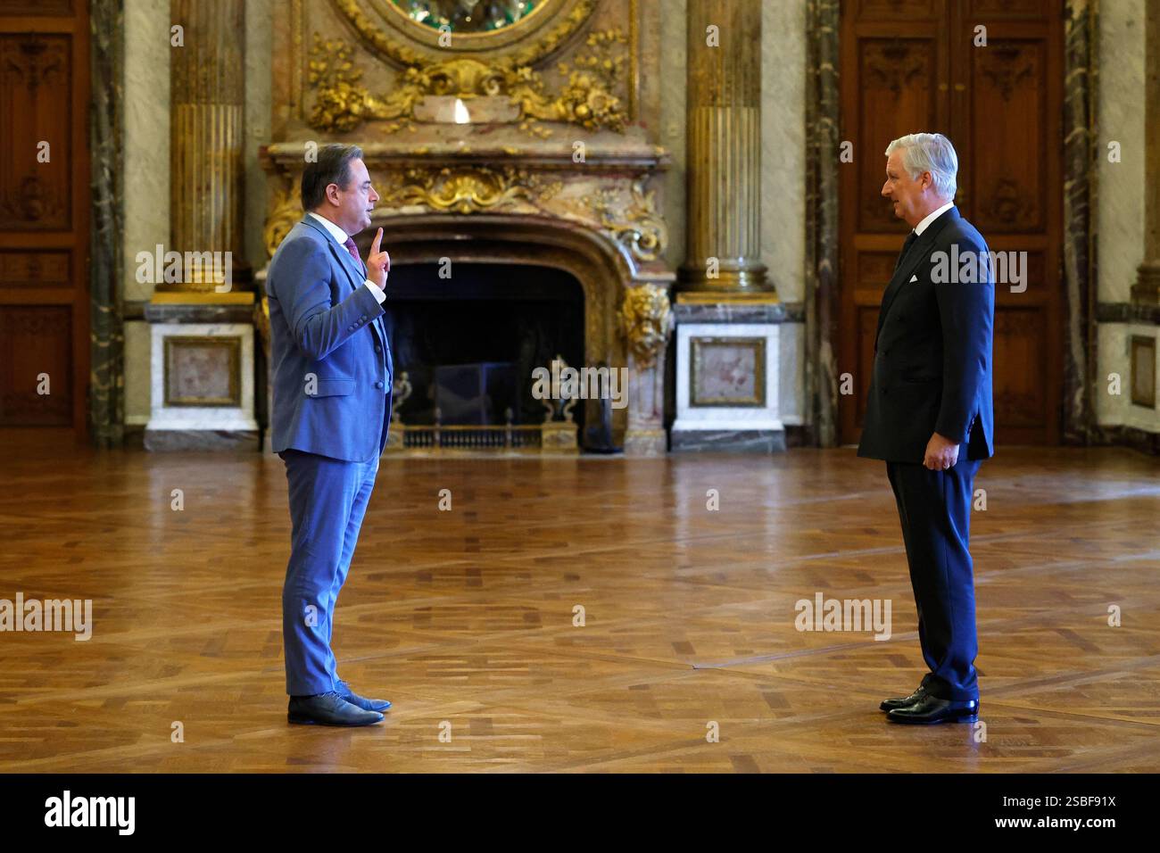 New Belgian Prime Minister Bart De Wever, left, raises his hand to take ...