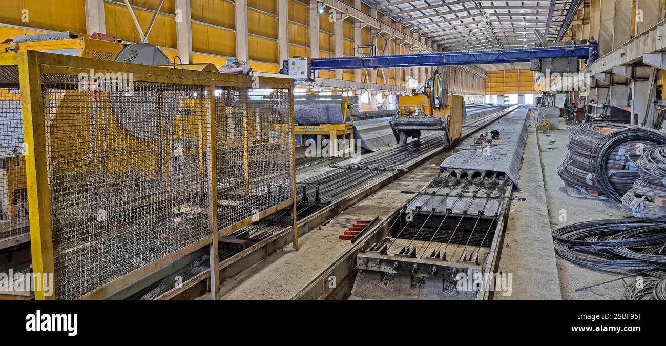 Precast concrete manufacturing plant with heavy machinery and ...