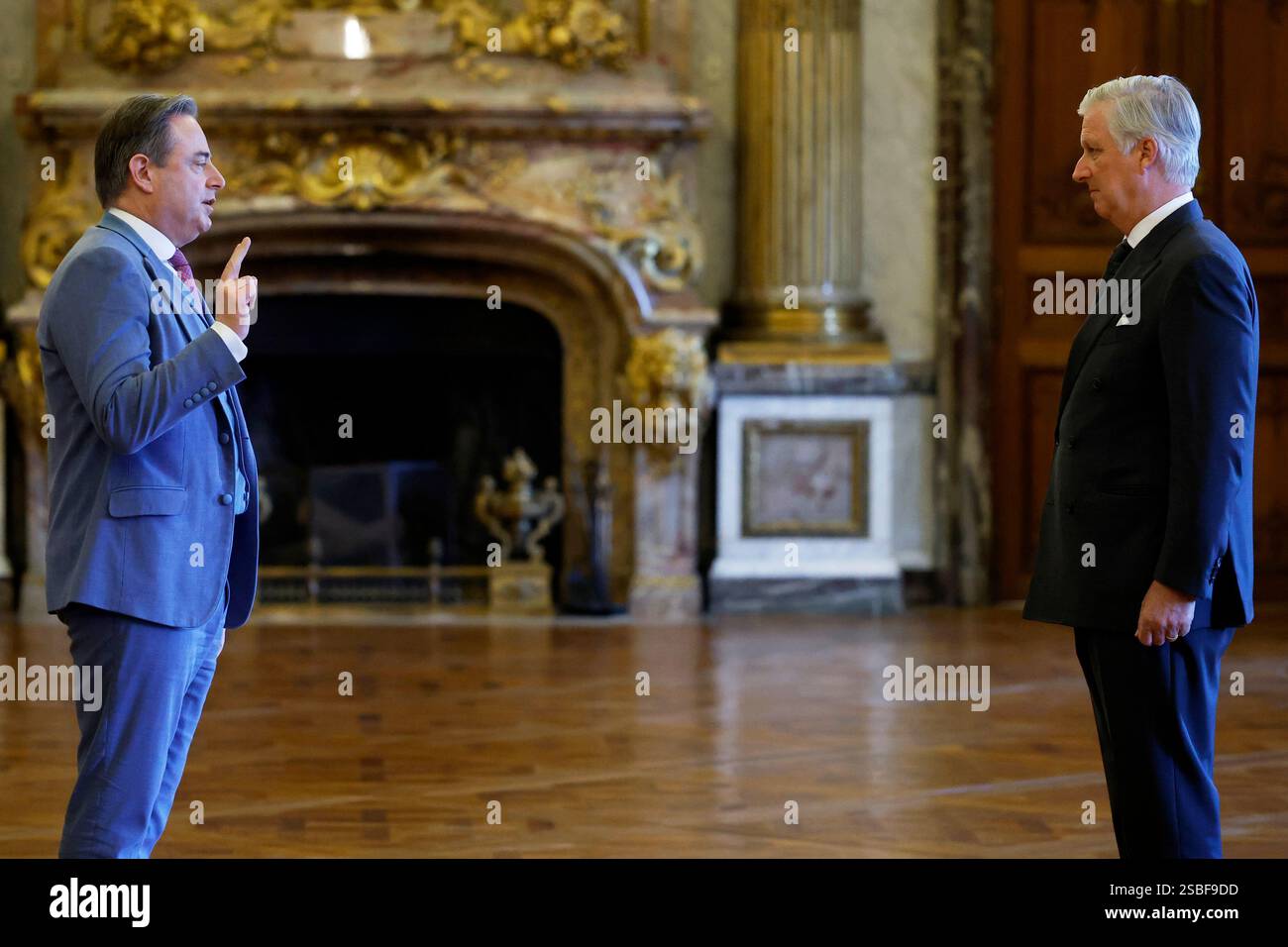 New Belgian Prime Minister Bart De Wever, left, raises his hand to take ...