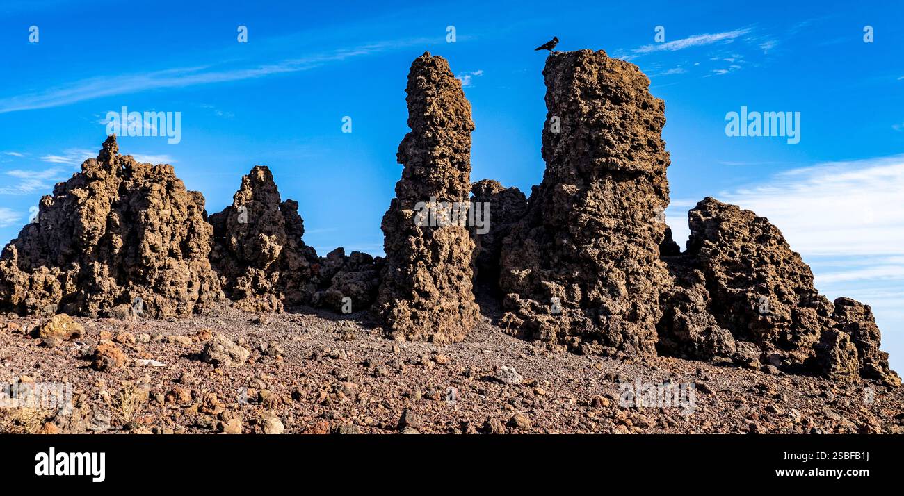 A rugged landscape featuring tall, jagged rock formations against a ...