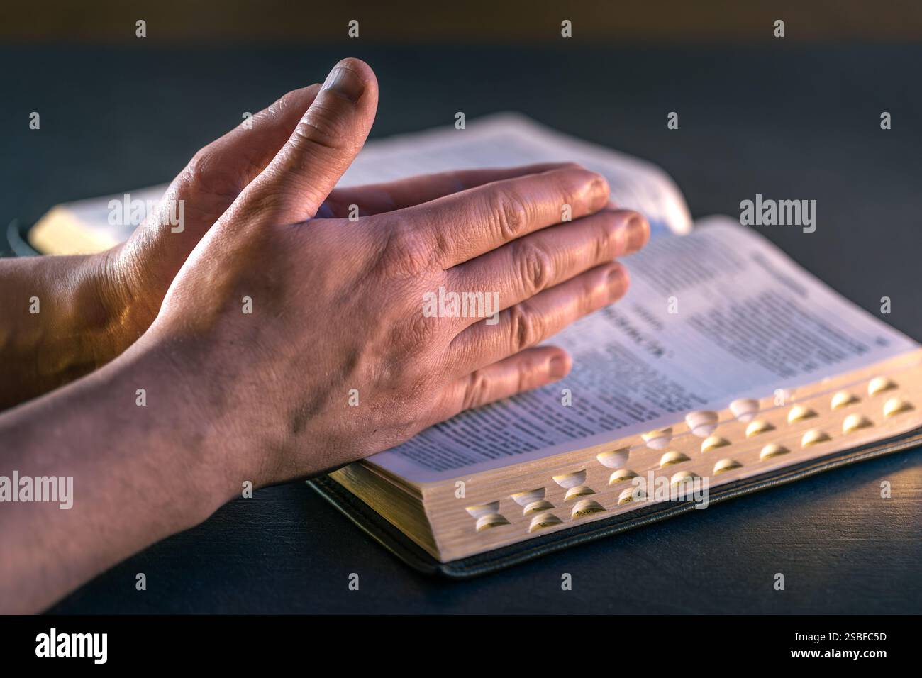Hands on the Holy Bible. Prayer. Open Bible close-up. Religion concept ...