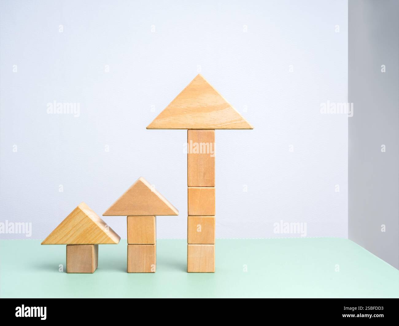 Three wooden arrowhead built by cube blocks as bar graph chart steps on ...