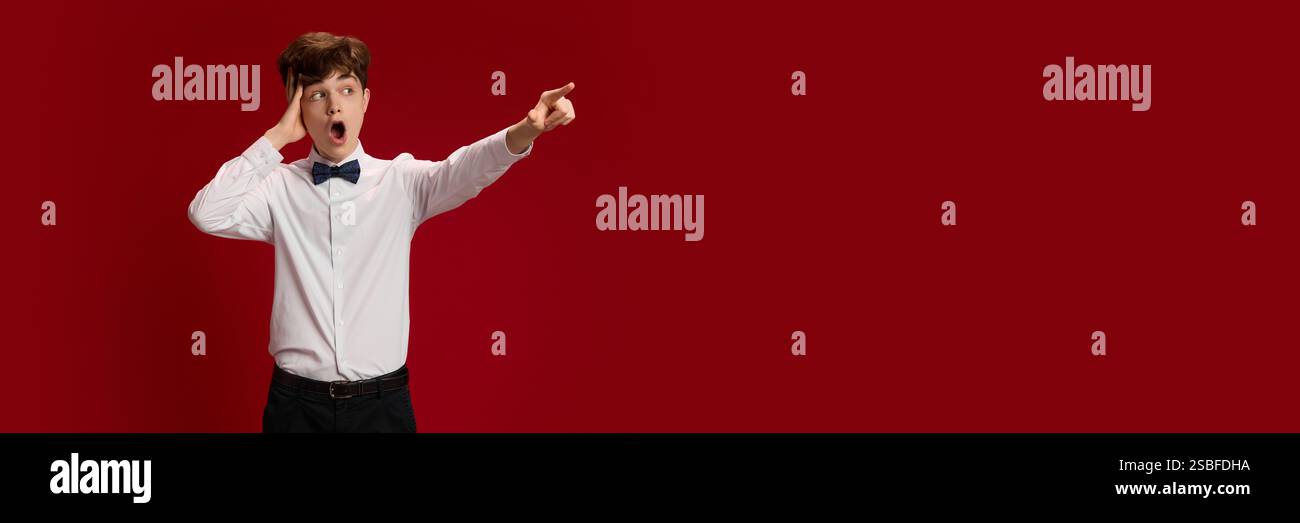Young emotional boy in white shirt and bow tie emotionally pointing ...