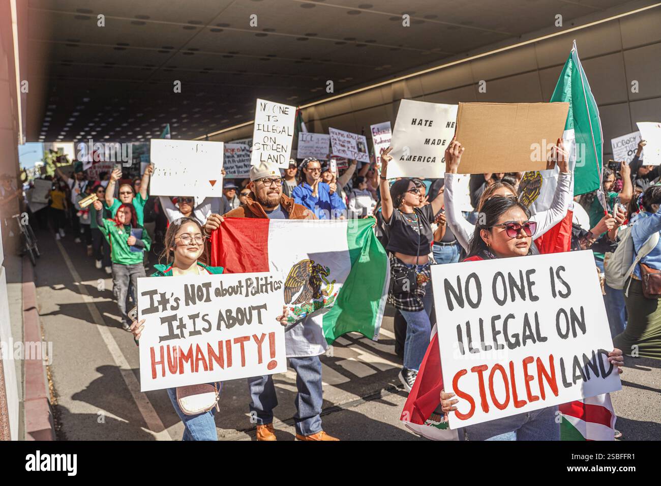 Protesters with Mexican flags and placards march on the street in ...
