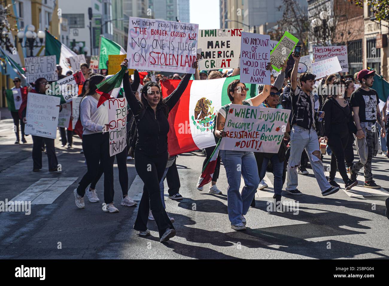 Protesters with Mexican flags and placards march on the street in ...