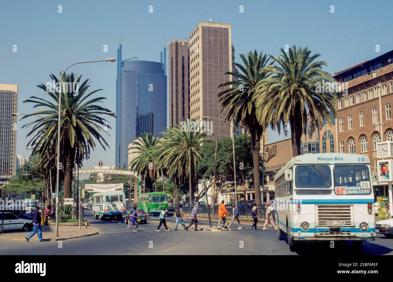 Kenia, a bus in the centre of Nairobi . Highrise and palmtrees along te ...