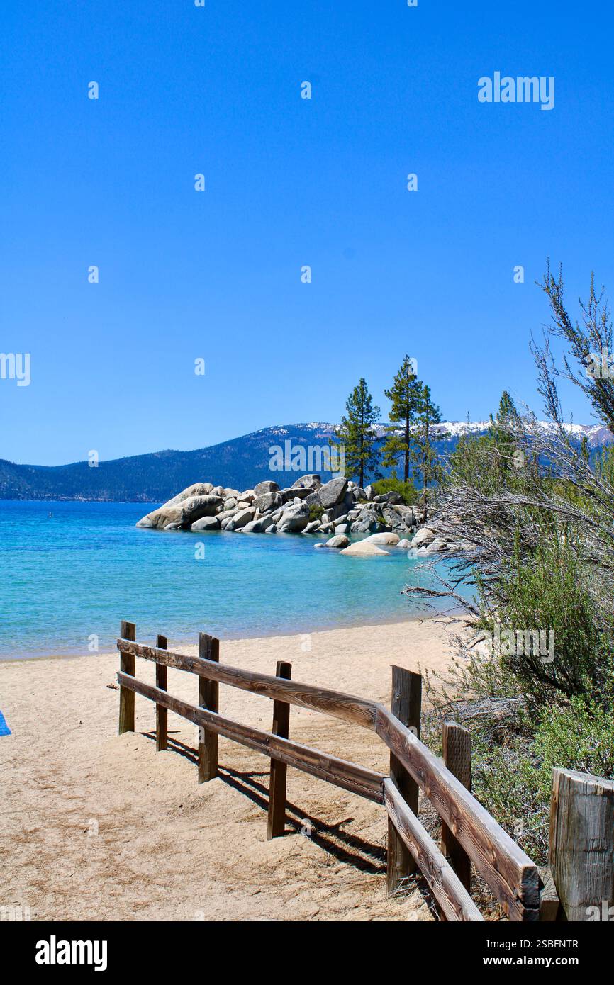 Scenic beach path with rocks and crystal-clear waters at Lake Tahoe ...