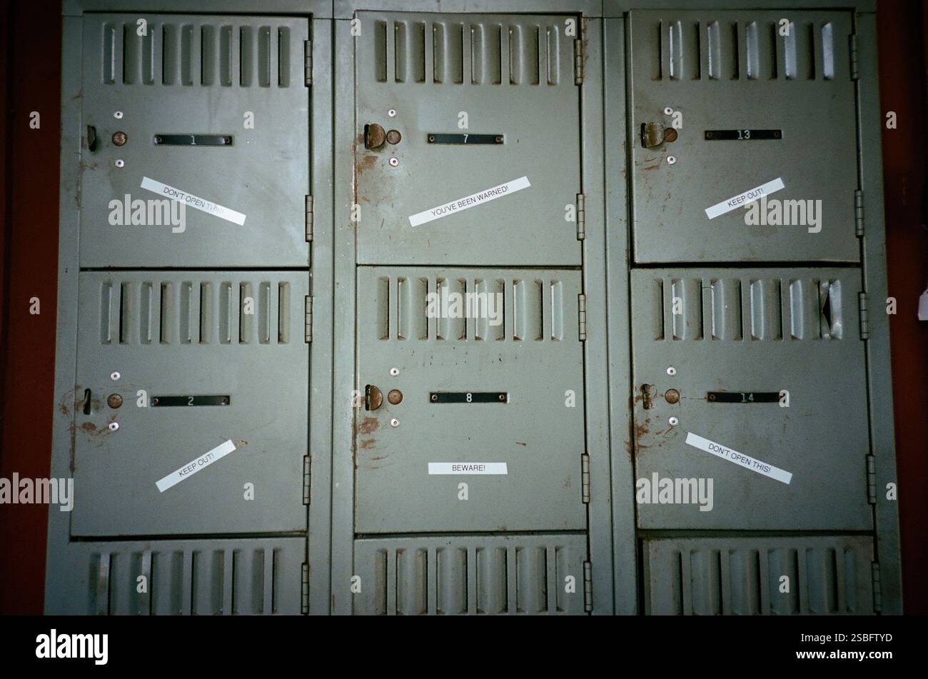 Rusty metal lockers with warning labels like "Keep Out" and "Beware ...