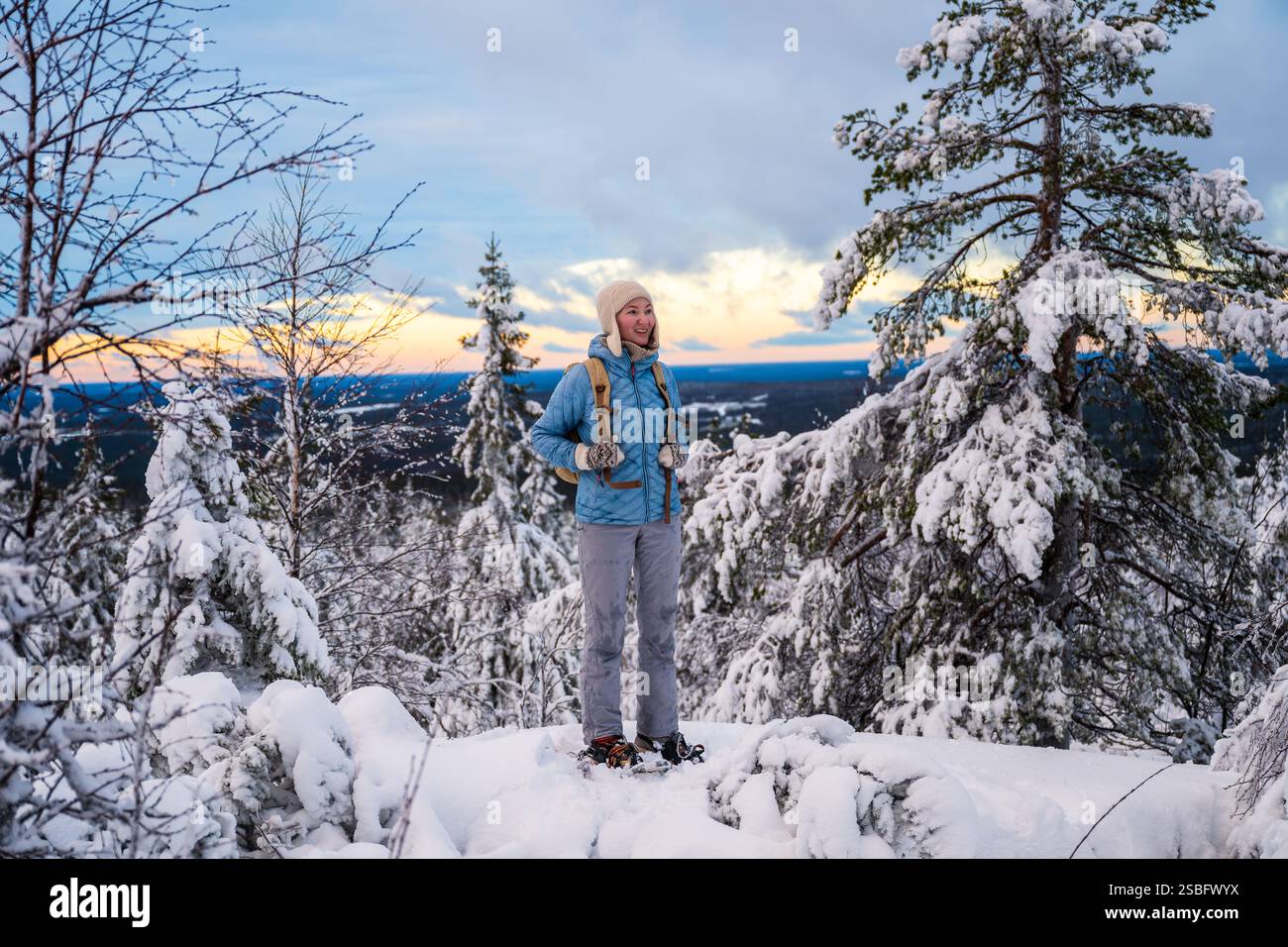 woman walks in Iso-SyÃ¶te National park of Finland with sunset sky ...