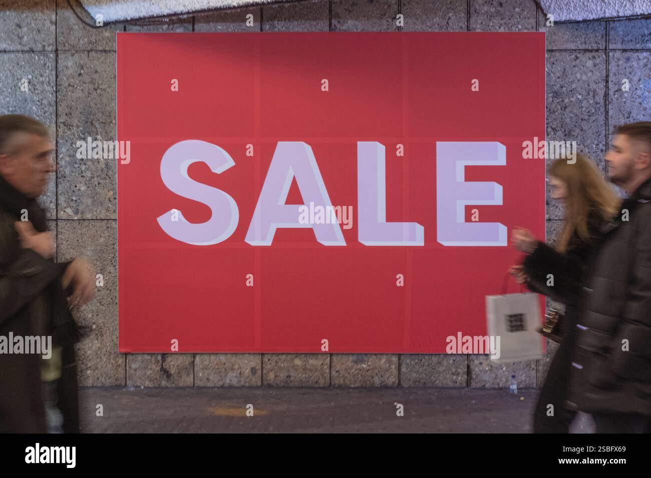 Abgebildet ist im Hintergrund auf rotem Banner ein Sale Schild , im ...