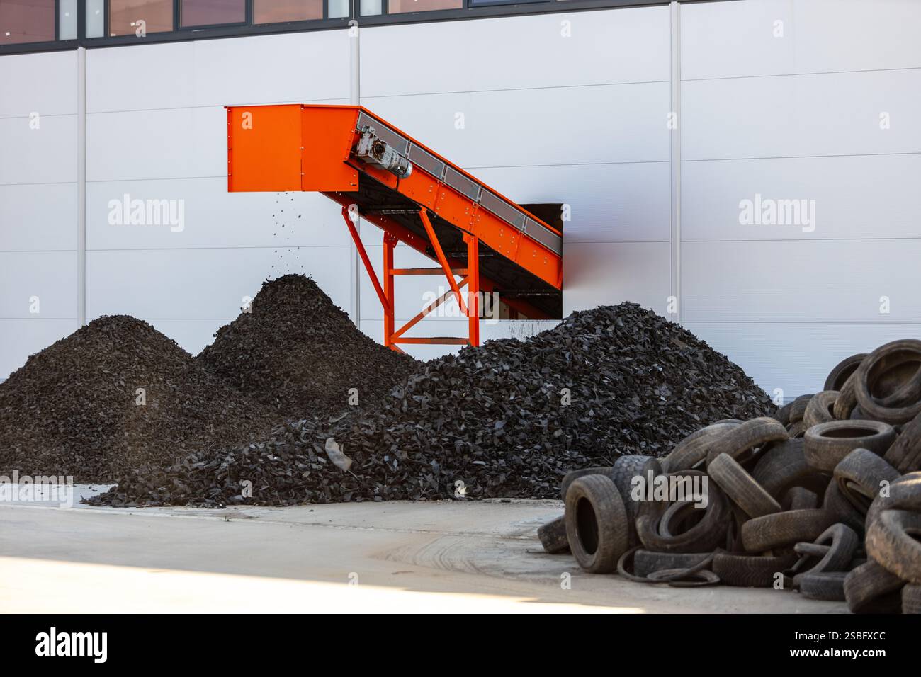 Tire recycling. Industrial conveyor belt transporting shredded rubber ...