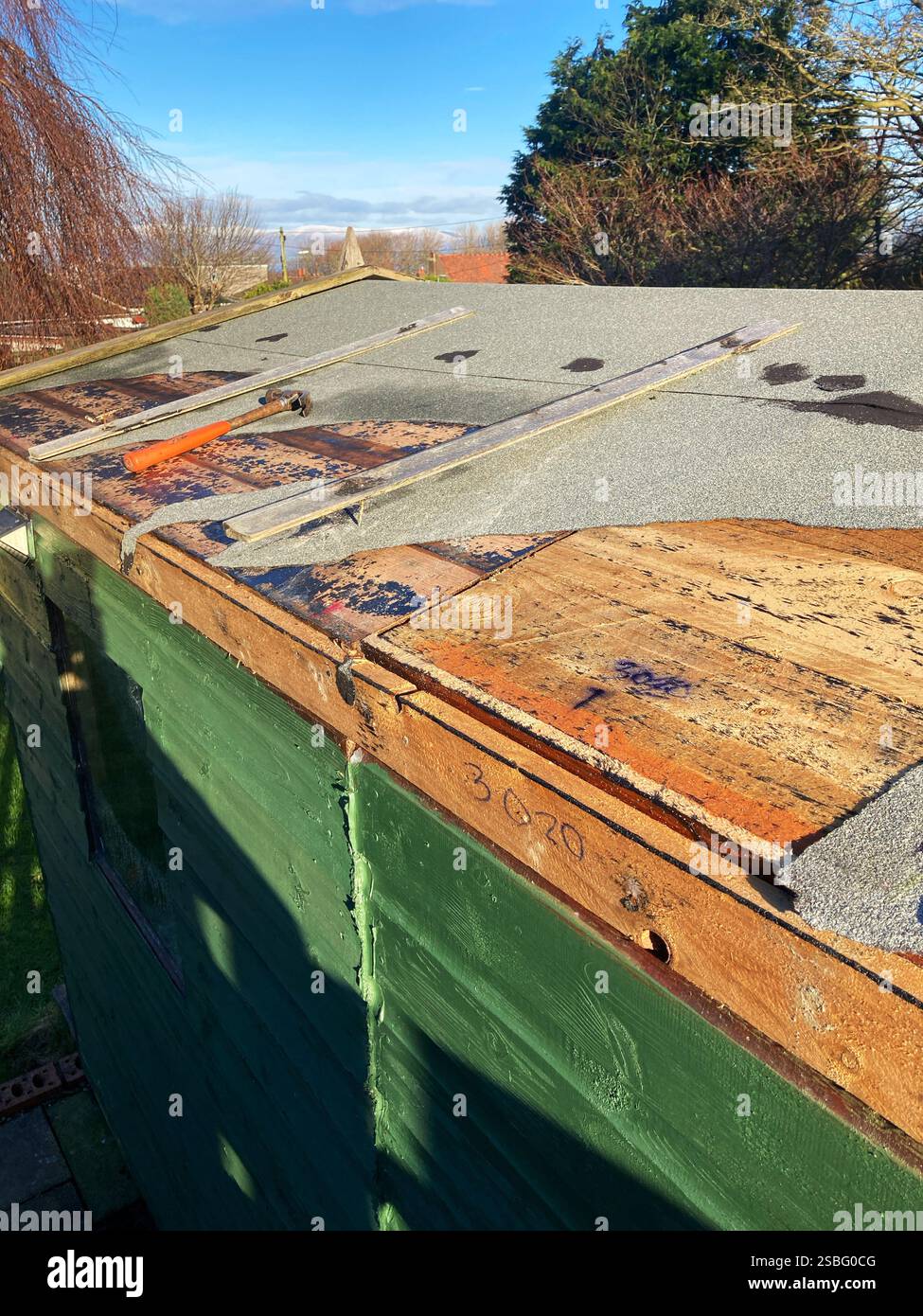 Old Garden Shed with a wind storm damaged roof with ripped felt and ...