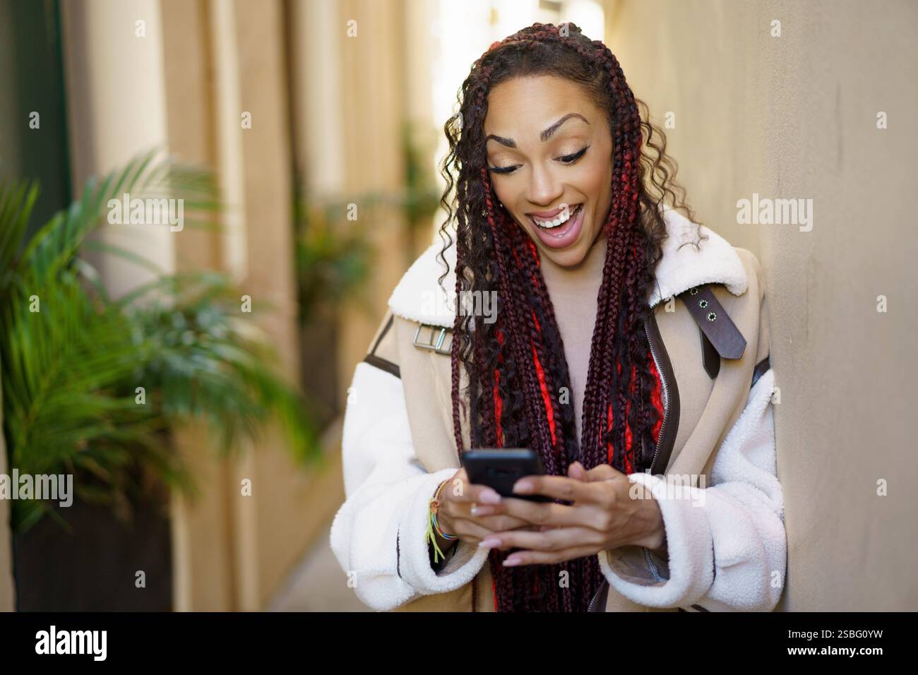A Joyful Woman Engaged with Her Smartphone While Enjoying an Urban ...