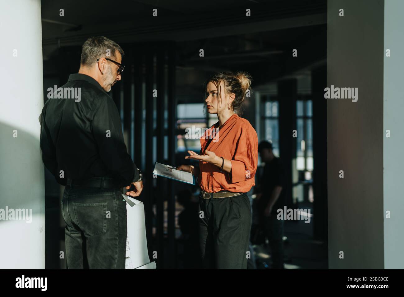 Two business people engage in a focused conversation in a contemporary ...