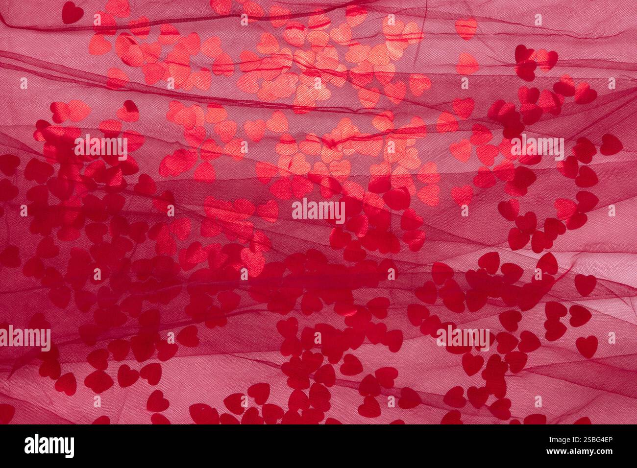 red metallic heart confetti on pink background with burgundy mesh ...