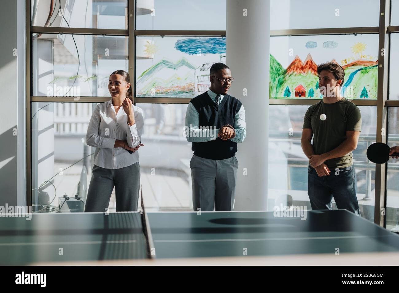 Multicultural business workers enjoying a friendly ping pong break ...