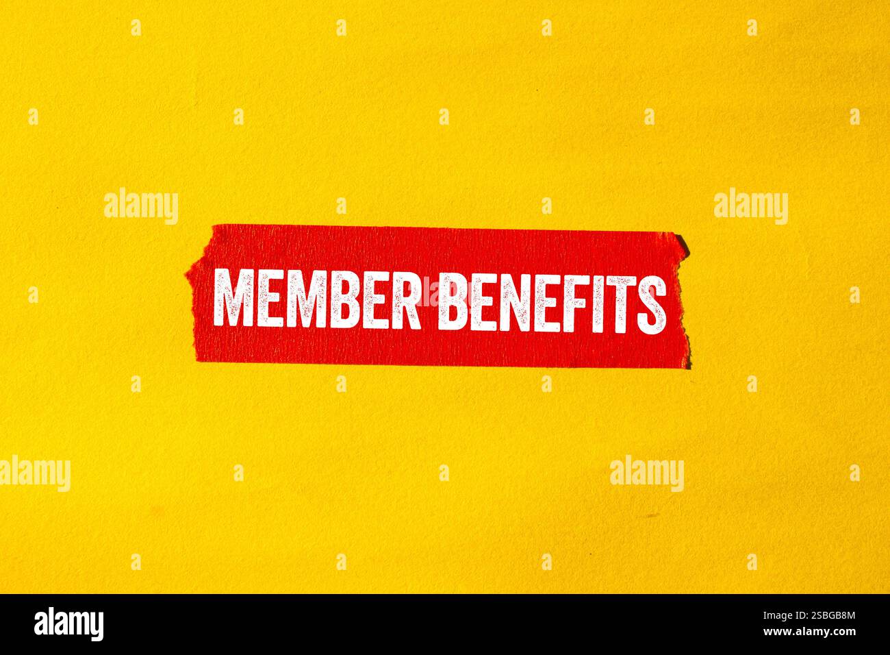 Member benefits message written on ripped torn red paper tape on yellow background. Conceptual ...