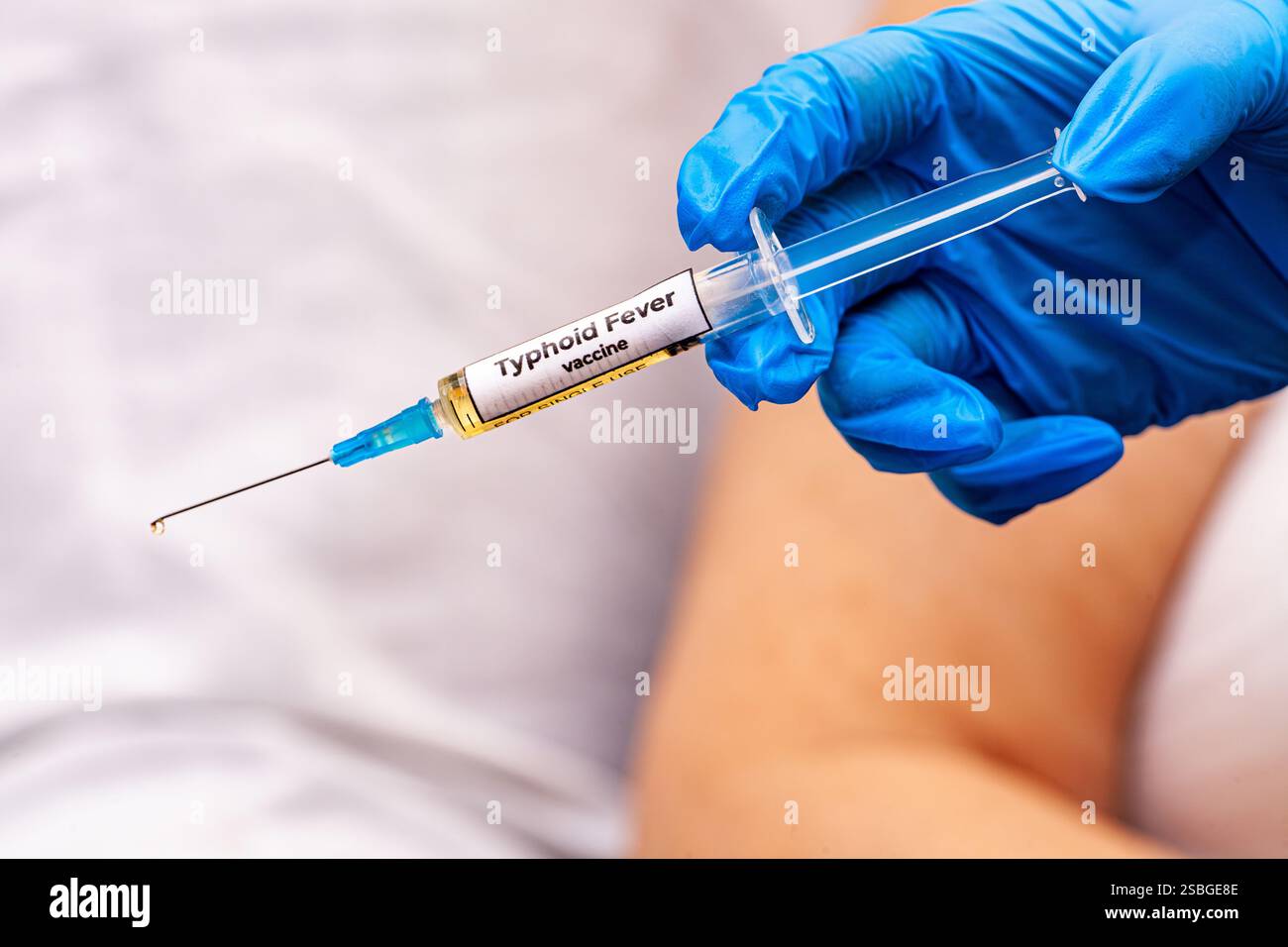 The picture shows a doctor holding a syringe with the typhoid fever ...