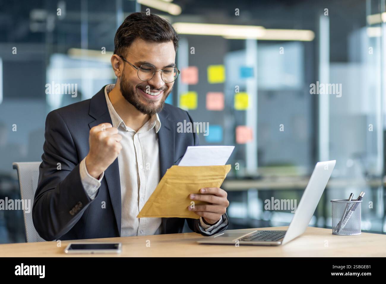 Successful businessman at workplace inside office with letter in hands ...