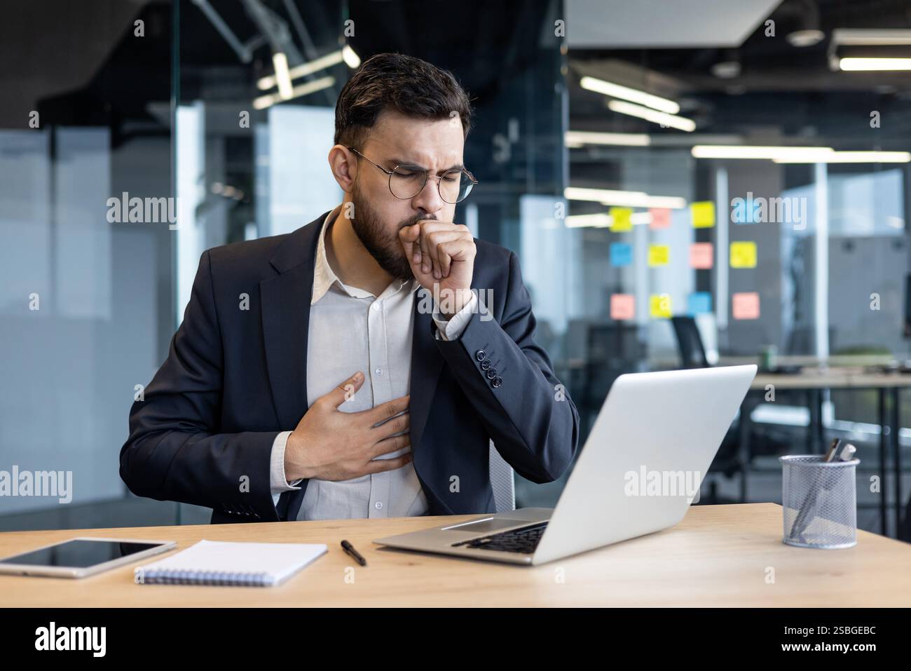 Sick man coughing and having a cold at workplace. Businessman working ...
