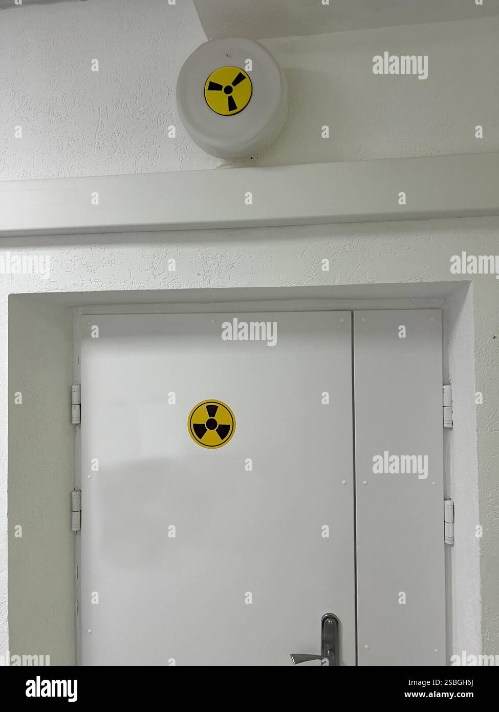 A white door marked with a radiation hazard symbol, emphasizing safety ...
