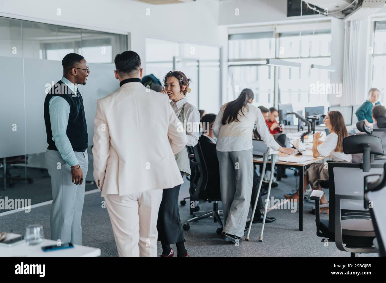 A group of multicultural employees engage in discussion and ...