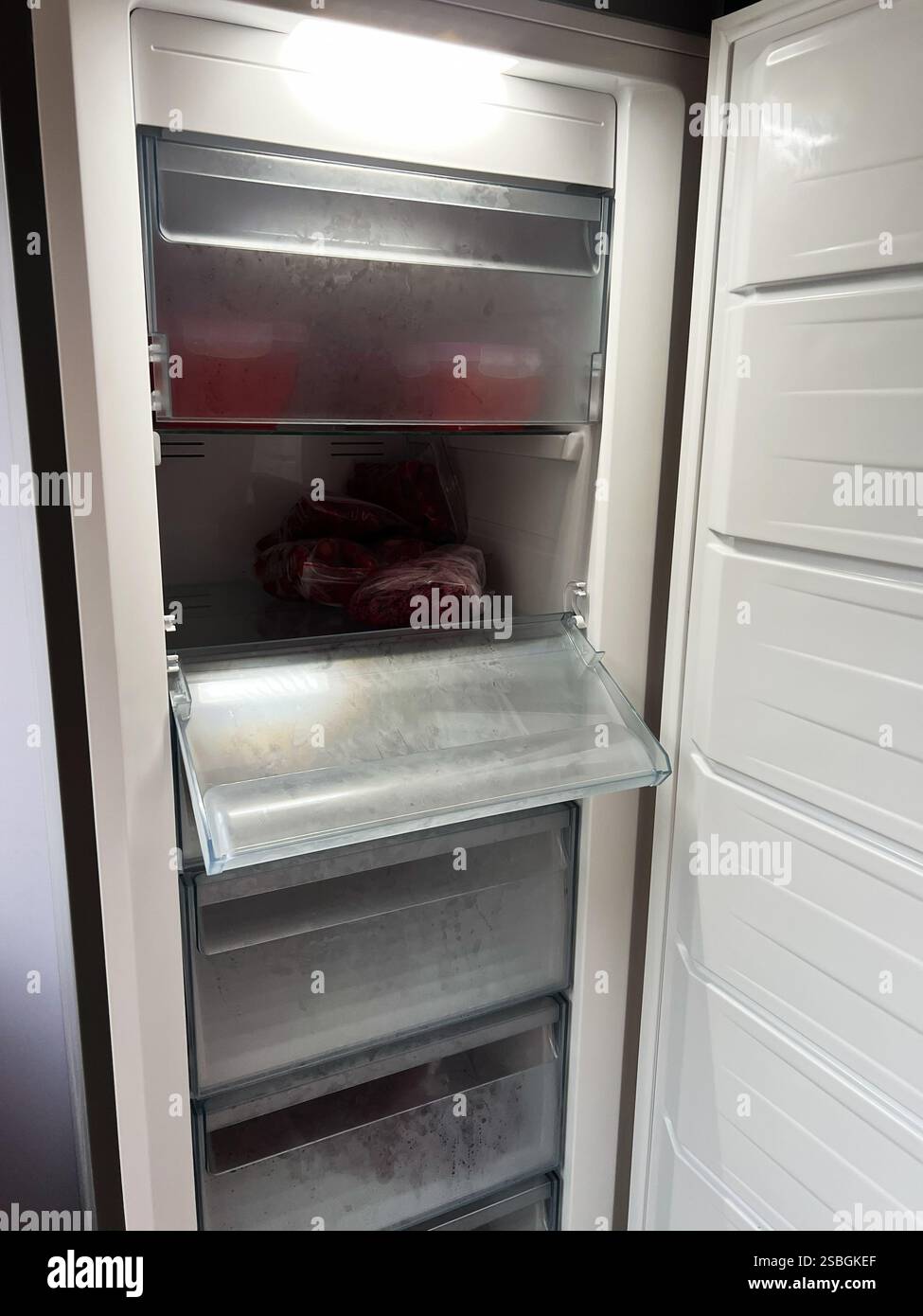 A detailed view of an open freezer showing organized drawers and stored ...