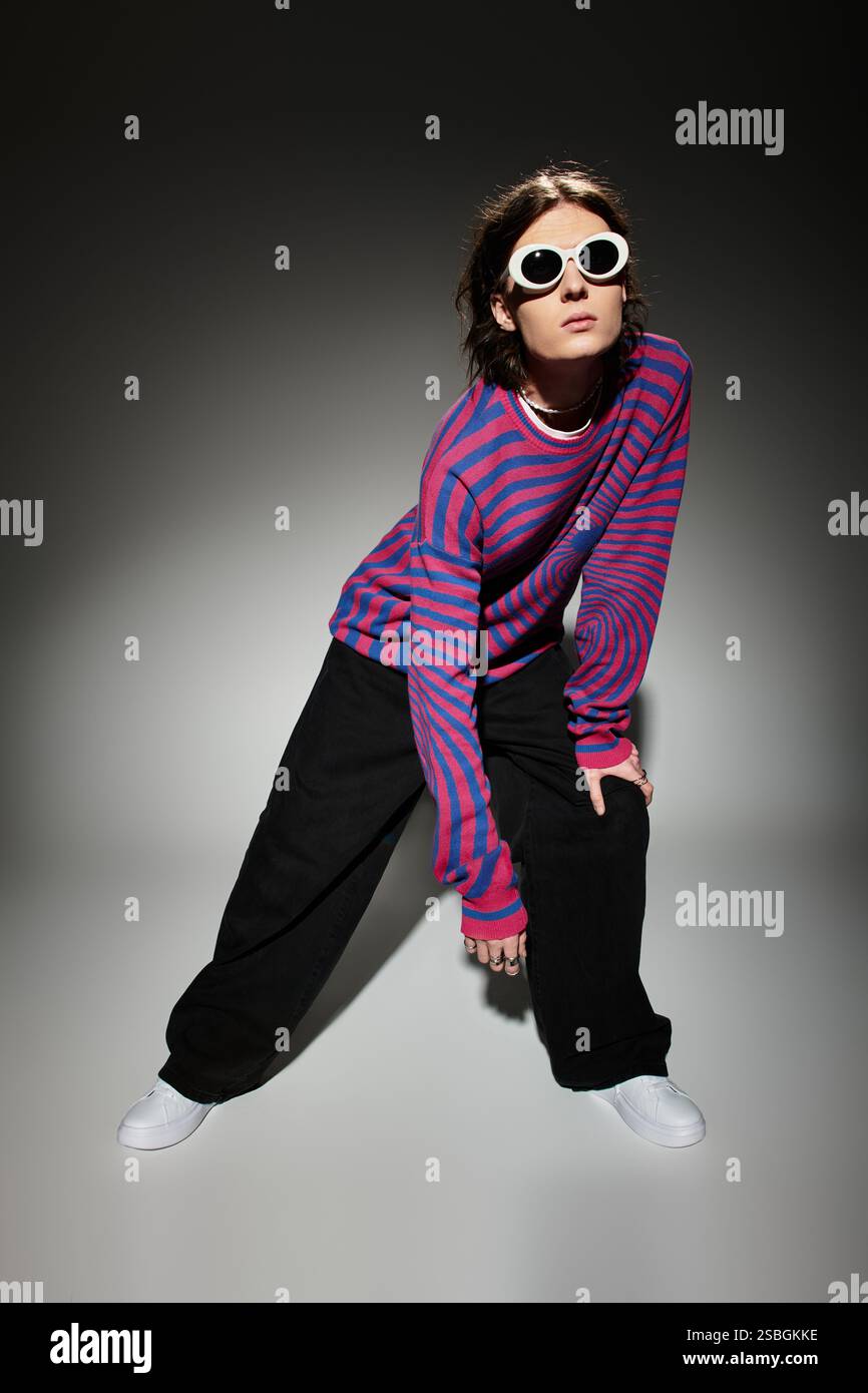 Captivating young man dressed in trendy attire strikes a unique pose ...