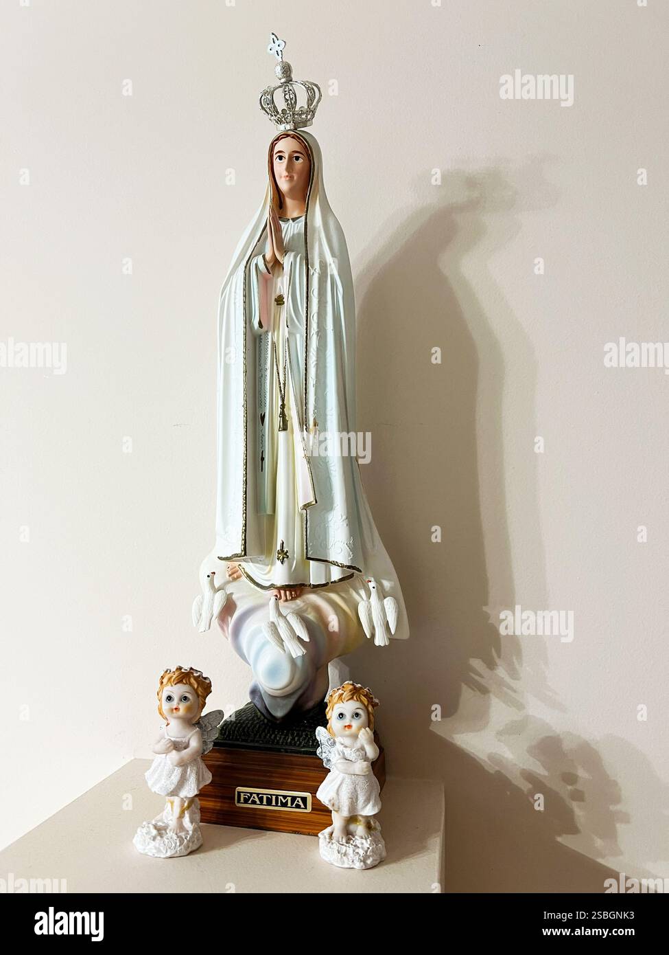 Sculpture of Our Lady of Fatima on a pedestal surrounded by angel ...