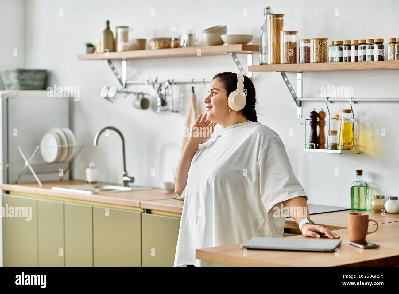 Plus sized woman wears headphones and smiles while standing in a chic ...