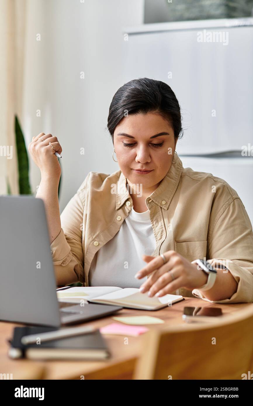 A beautiful plus sized woman thoughtfully writes notes at her desk ...