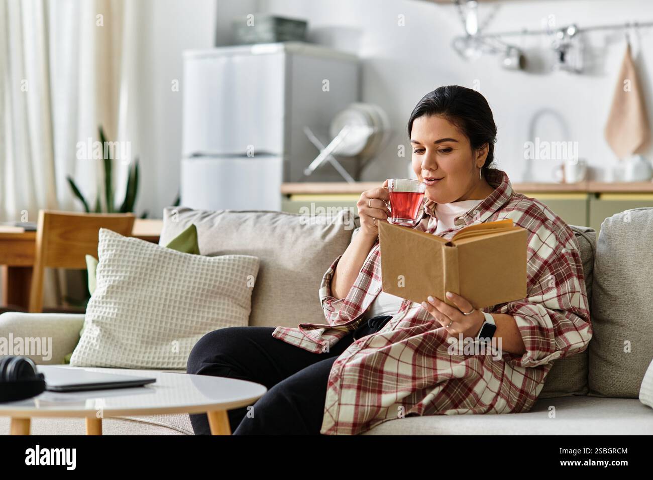 Woman sipping tea reading on hi-res stock photography and images - Alamy