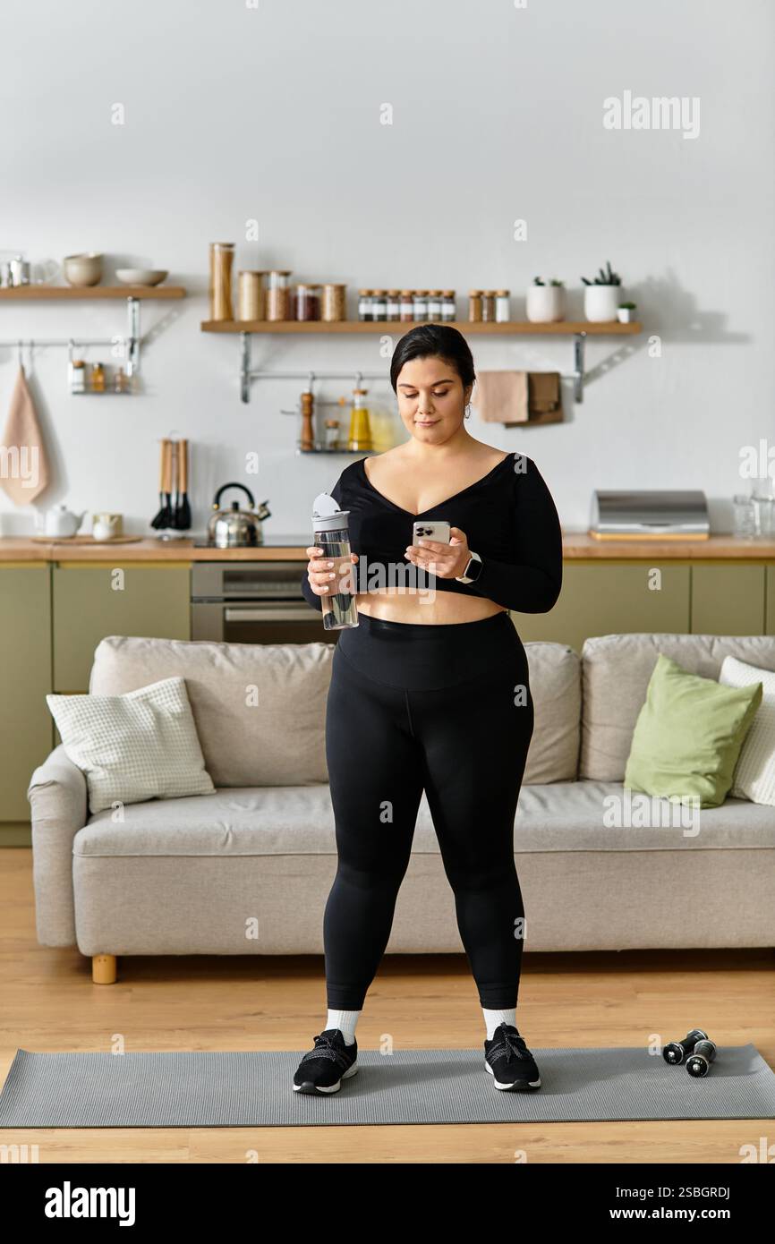 A young plus sized woman in her home gym gets ready for a workout with ...