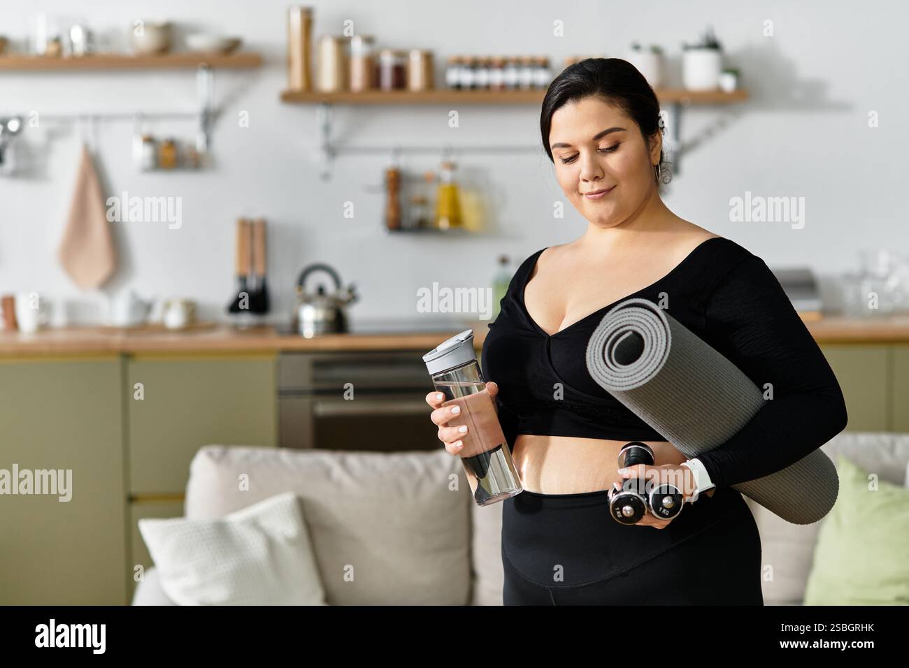 A young plus size woman preps for a workout in her bright, inviting ...