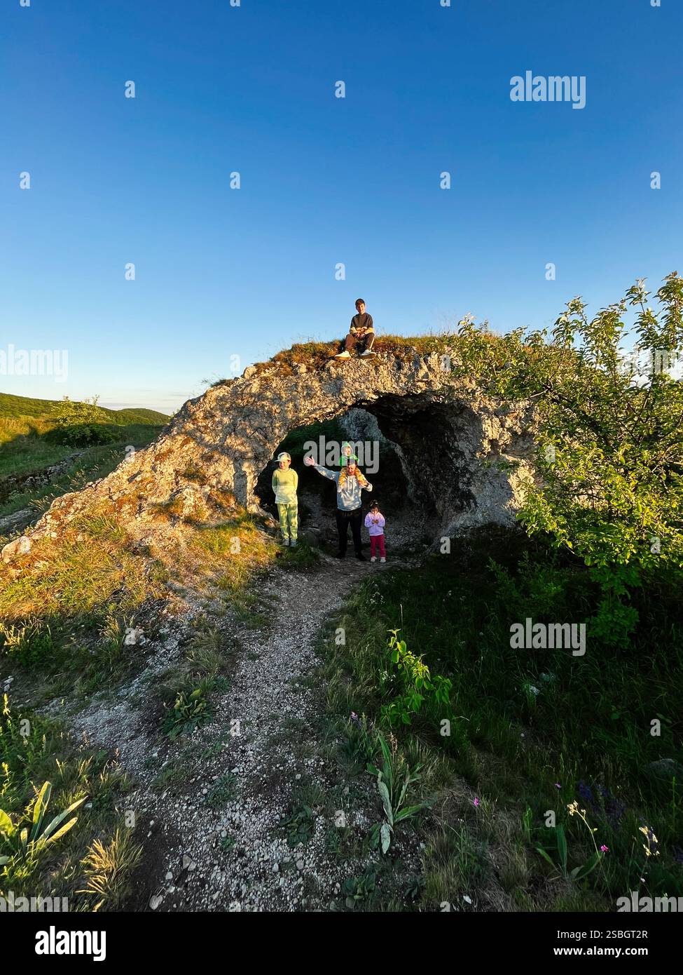 A family enjoys a bright sunny day exploring a stunning natural stone ...