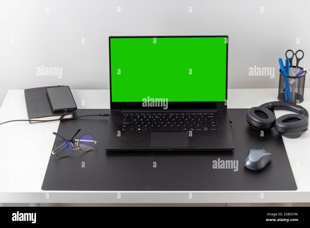 Workplace, laptop computer with blank empty green screen display monitor on desk. Mock up, copy ...