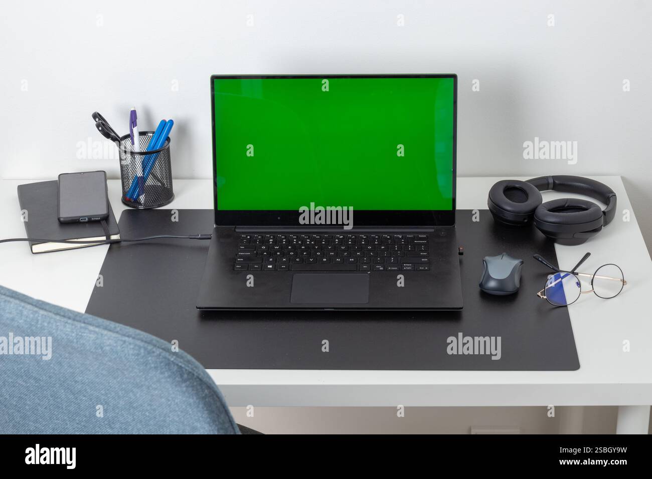 Workplace, laptop computer with blank empty green screen display monitor on desk. Mock up, copy ...