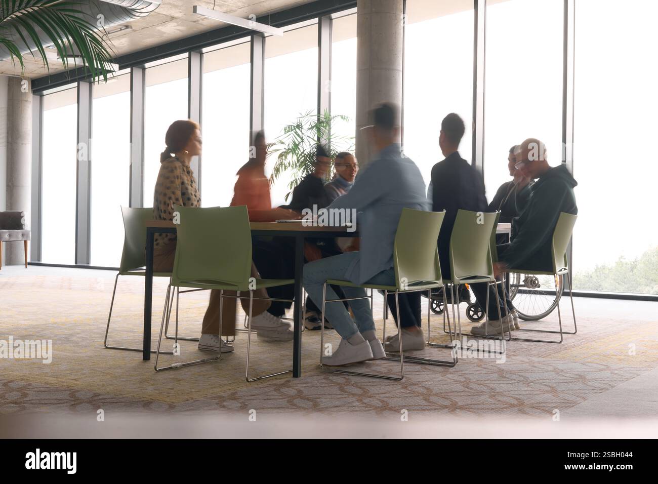 A diverse business team, working urgently around a conference table ...