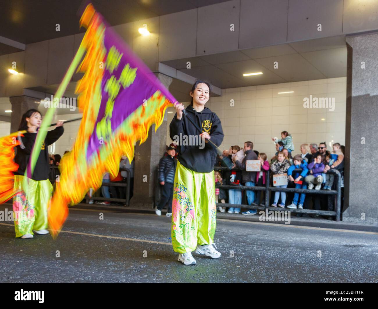young asian woman in costume waving traditional banner flag at Chinese ...