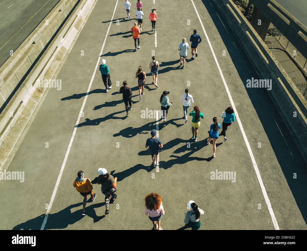Aerial view of a diverse group of runners jogging together on a wide ...