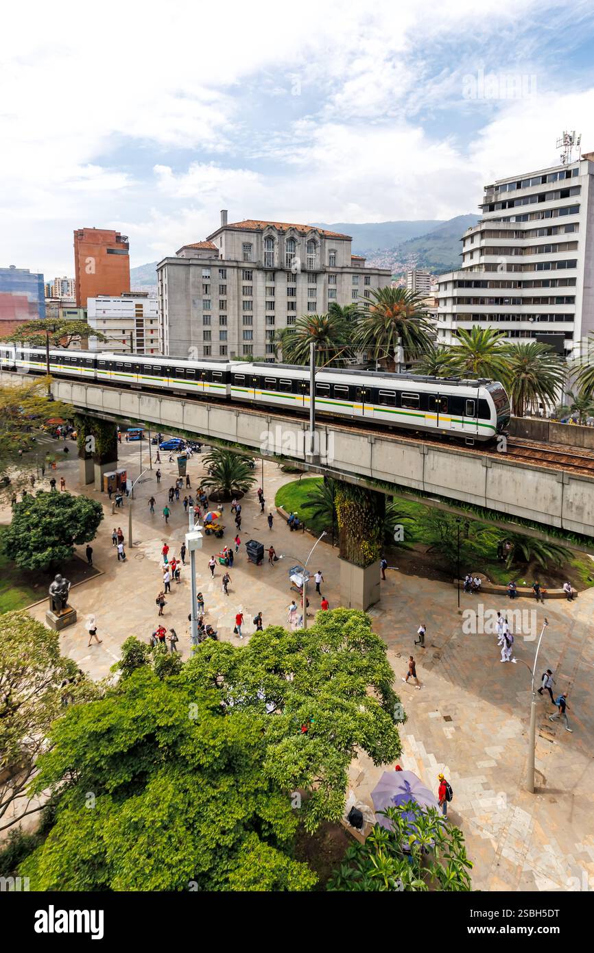 Medellin skyline with Metro de Medellín train at Plaza Botero square ...