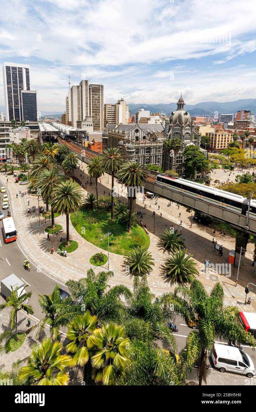 Medellin skyline with Metro de Medellín train at Plaza Botero square ...