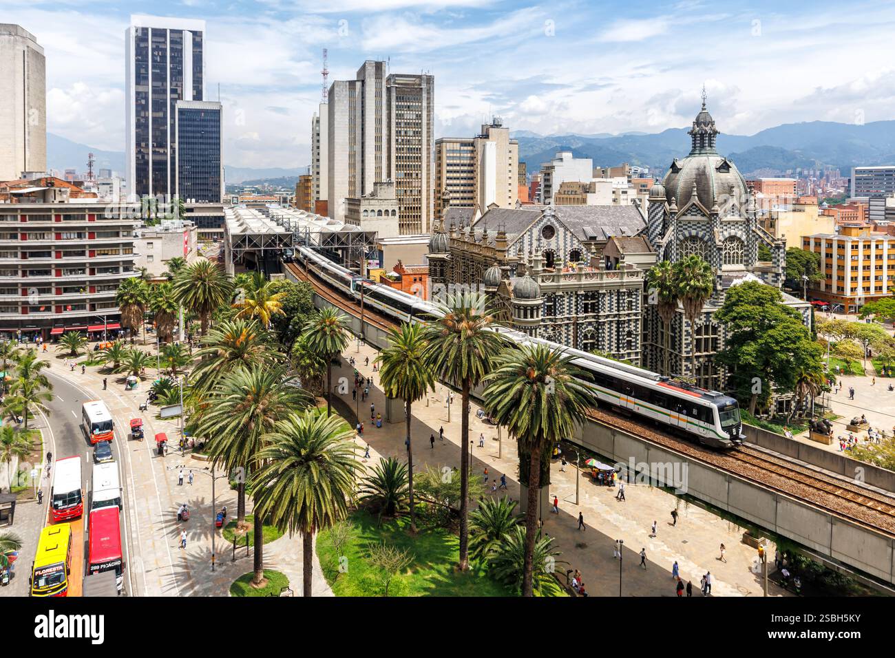 Medellin skyline with Metro de Medellín train at Plaza Botero square in ...