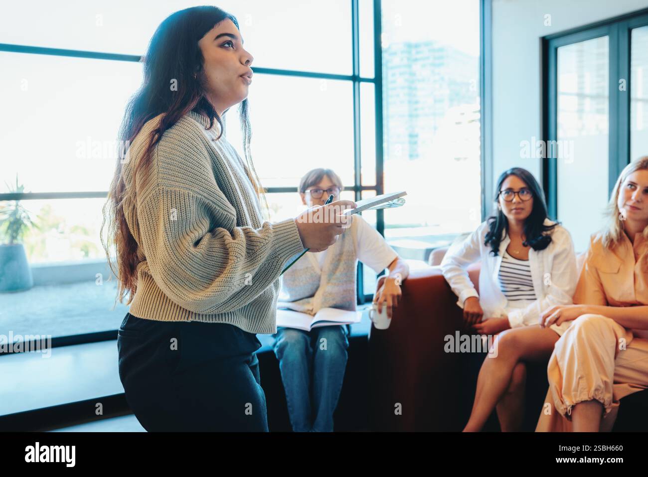 Female student confidently delivering a presentation in a class ...