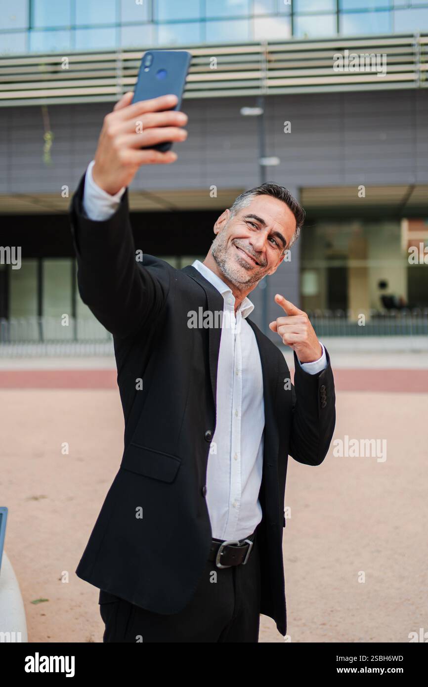 A Confident Businessman Takes A Selfie With His Smartphone, Smiling ...
