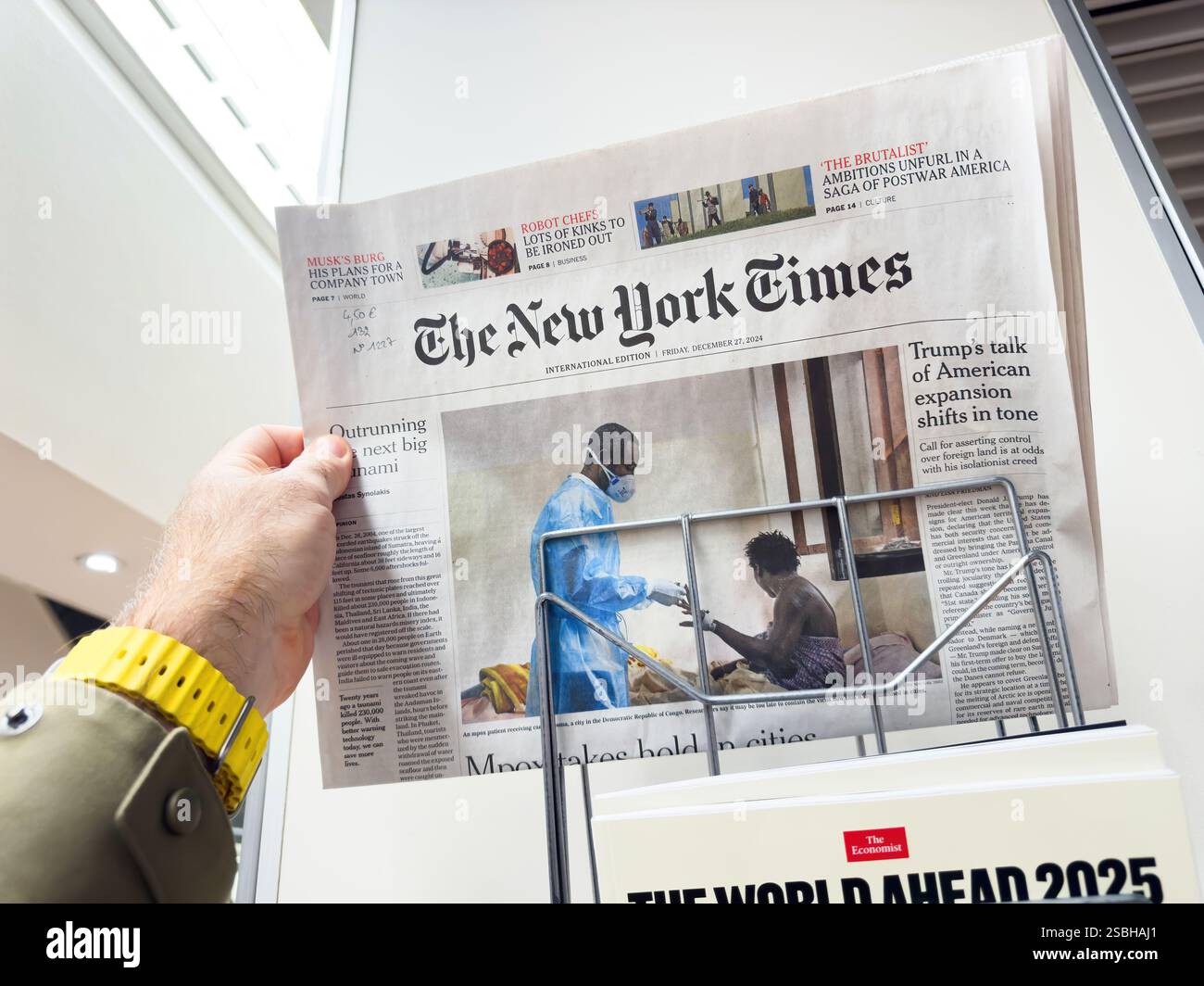 Paris, France - Dec 28, 2024: A hand holds the international edition of ...